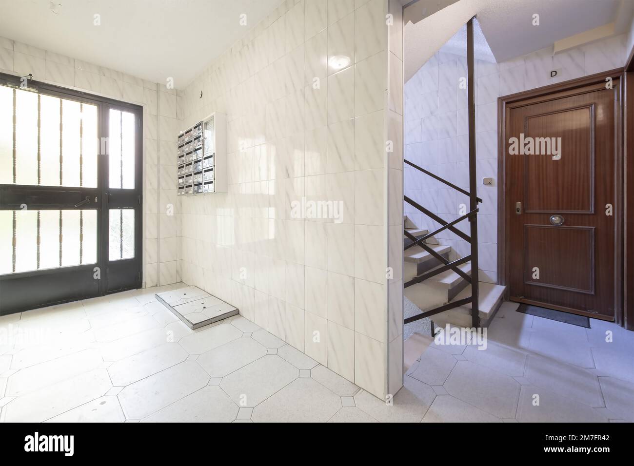 Portal of an old residential building with metal stairs and stone steps ...