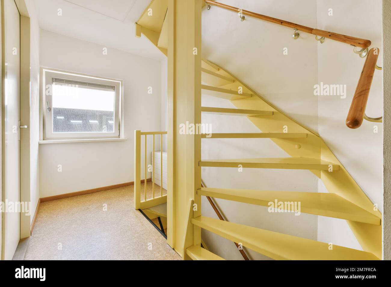 a yellow staircase in a white room with beige carpet and light wood ...