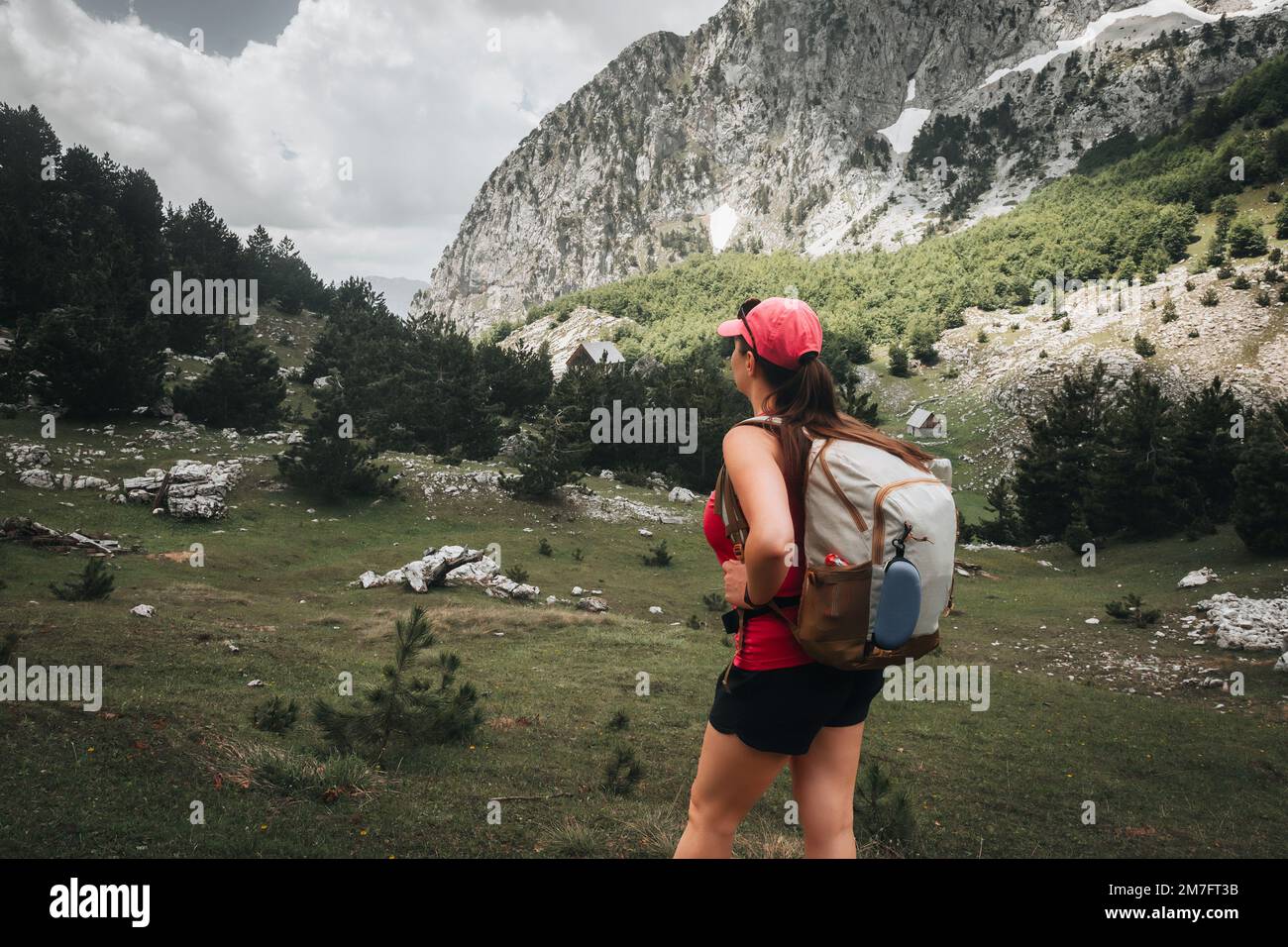 Hiker girl on a trail in the mountains of Albania. A tourist with a ...