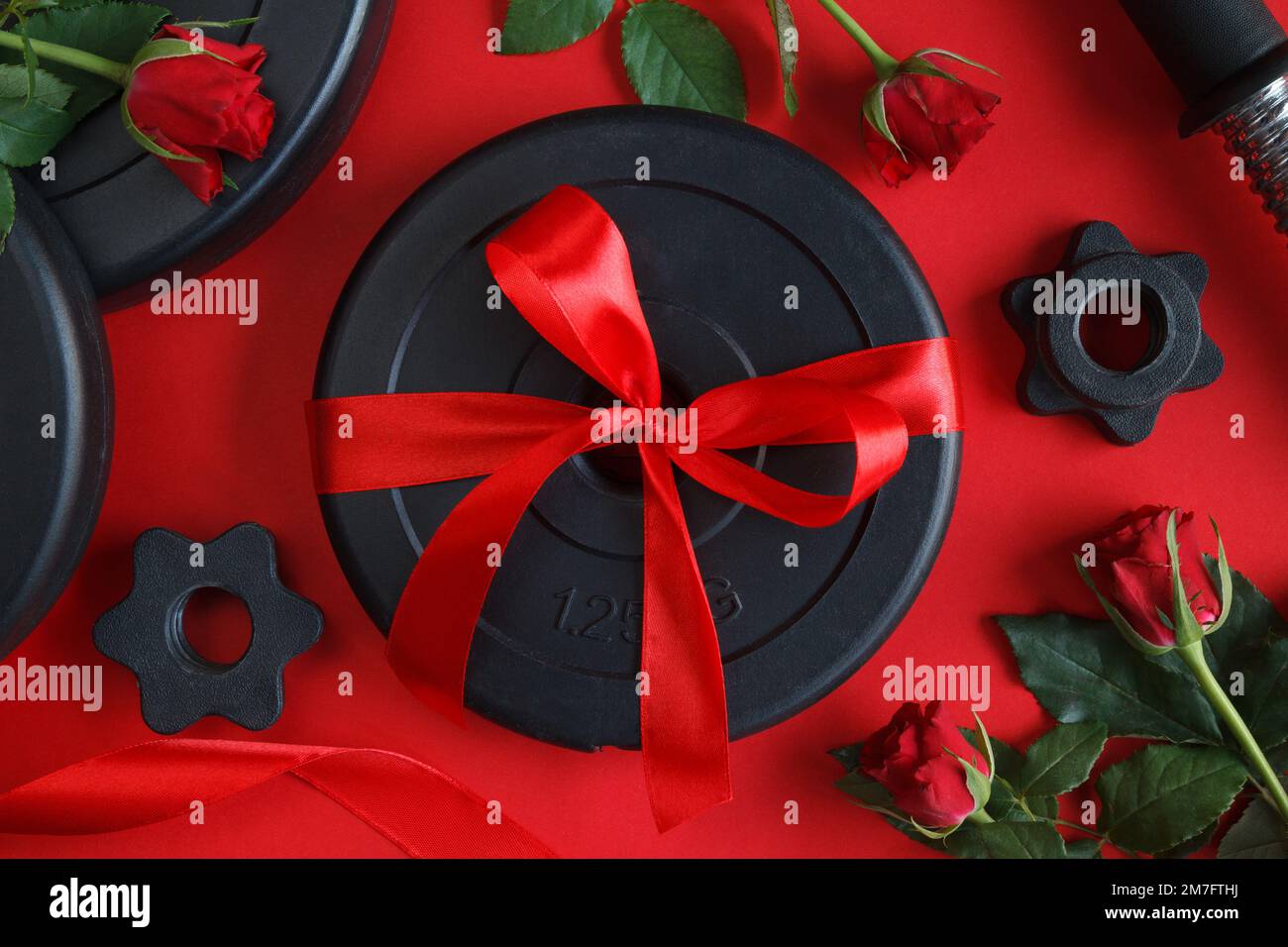 Ribbon wrapped dumbbell barbell weight plate and red roses. Love gift ...