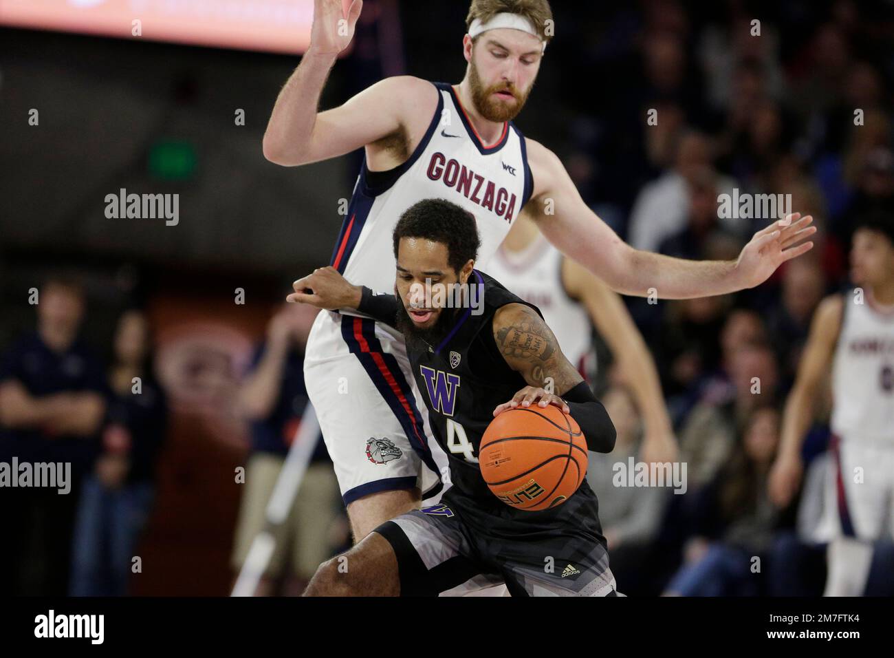 Washington guard PJ Fuller II, front, controls the ball while defended ...