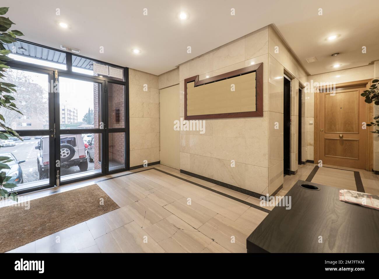 Lobby of a residential building with a table for the concierge, marble ...