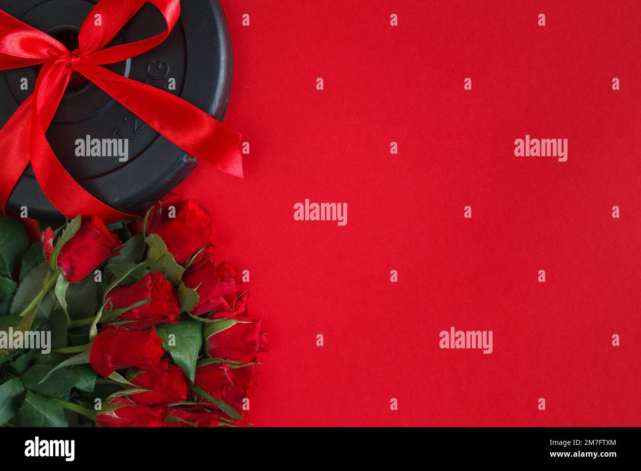 Ribbon wrapped dumbbell barbell weight plate and red roses. Love gift ...
