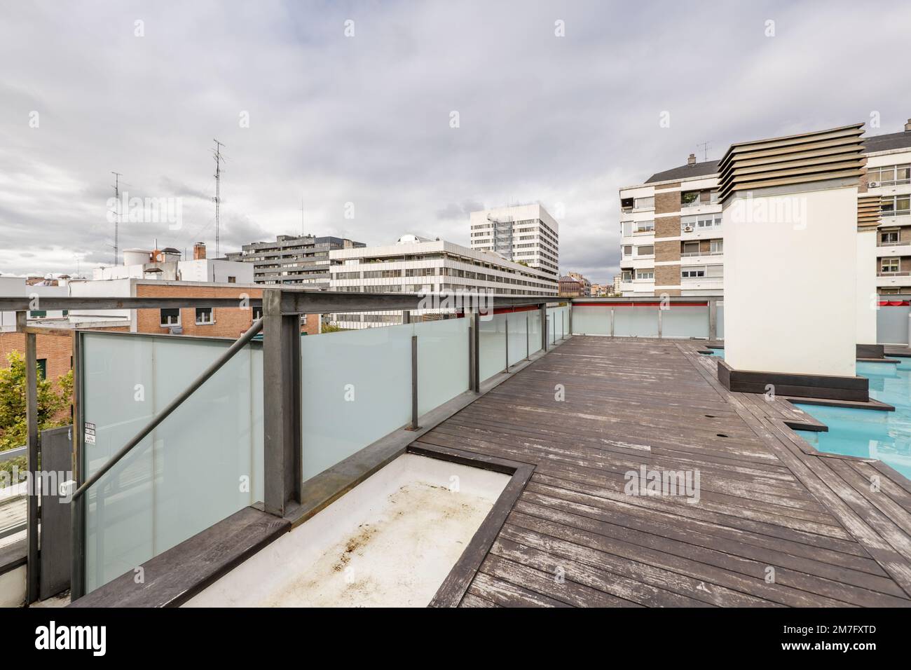 Terrace in the attic of a building with acacia wood floors and metal ...