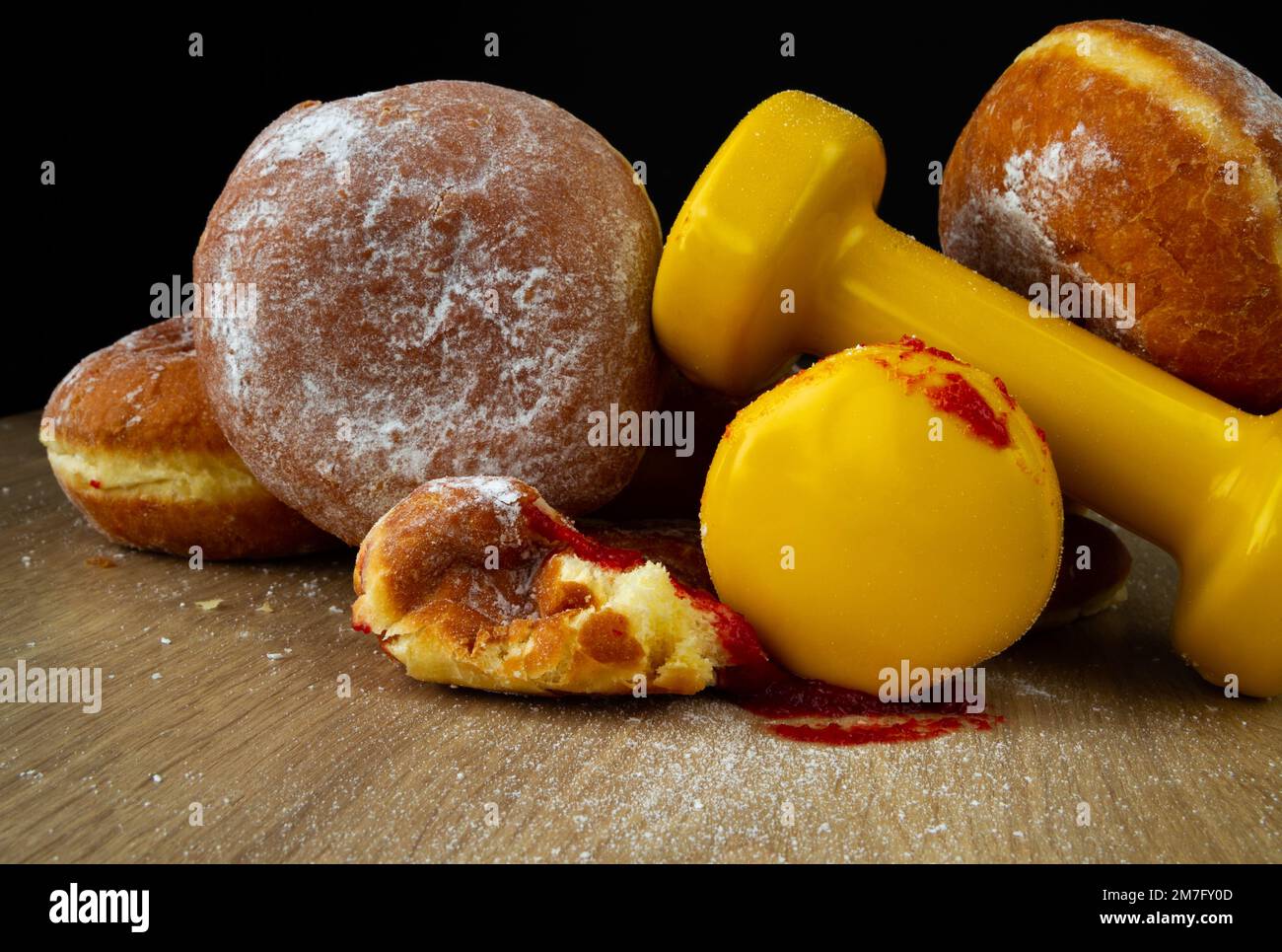 Gym dumbbells crushing Polish pączki deep-fried doughnuts. Fat Thursday ...
