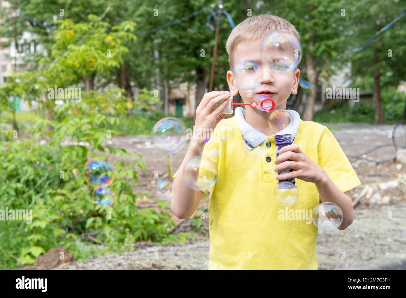 Happy little boy have fun blowing colorful shiny rainbow bubbles ...