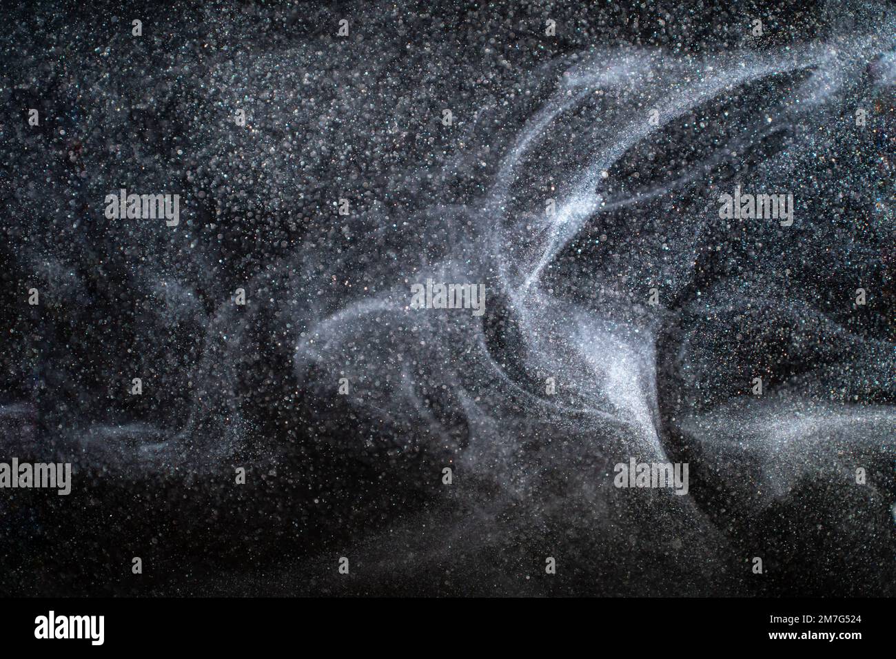 Dust particles cloud generating abstract shapes with black background ...