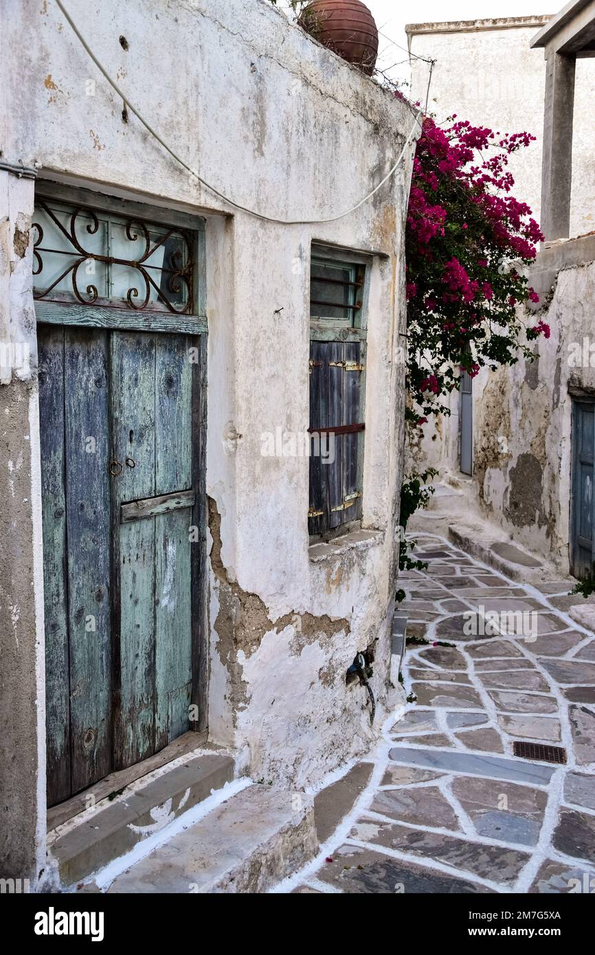 A vertical shot of a narrow path between traditional white Greek houses ...