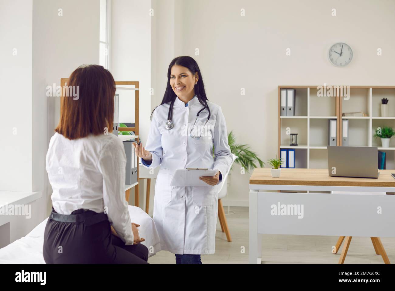 Friendly female doctor is talking to her female patient during medical ...