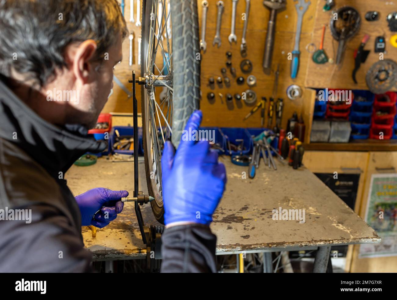 Cycling technician repairing bike wheel and spokes in workshop Stock ...