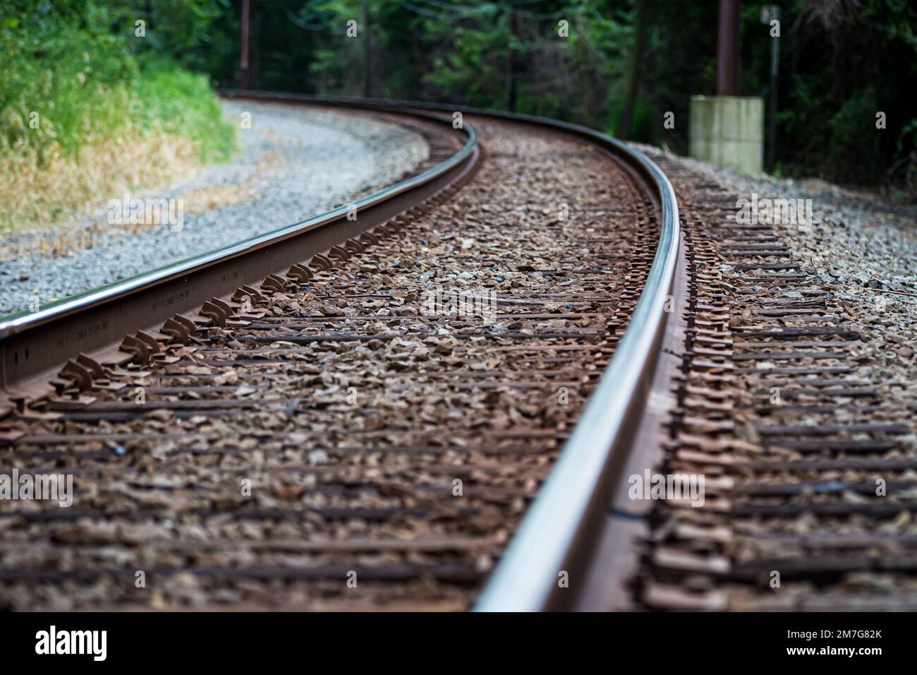 An empty railway track passing through a green landscape during the ...