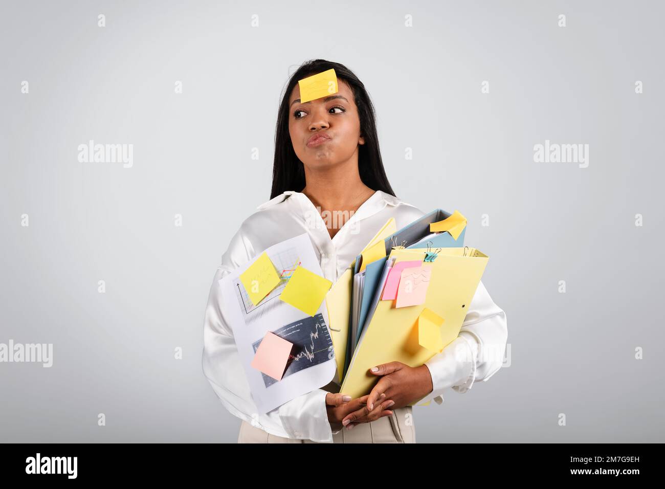 Tired busy millennial black female in white blouse hold many folders of ...