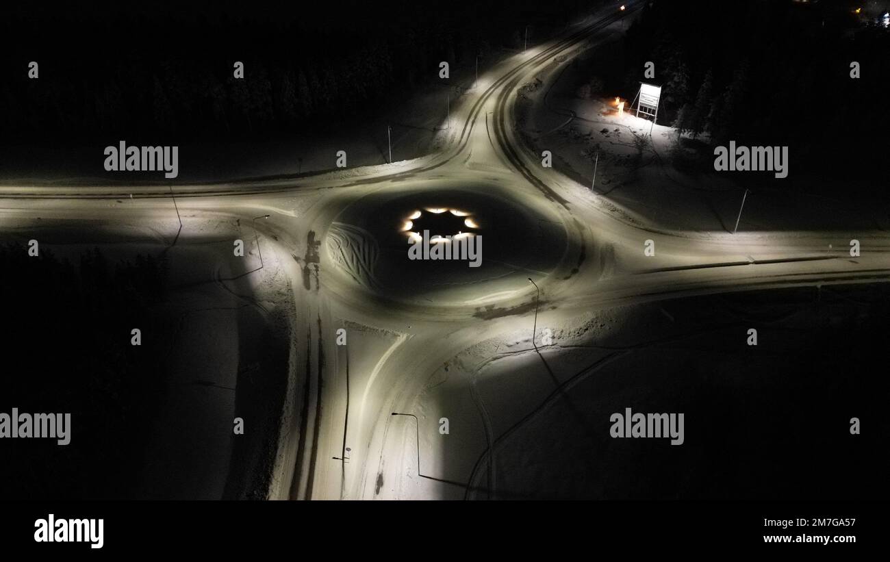 An aerial view of slightly illuminated empty suburban roundabout in ...