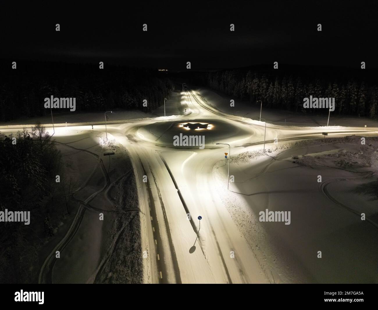 An aerial view of slightly illuminated empty suburban roundabout in ...