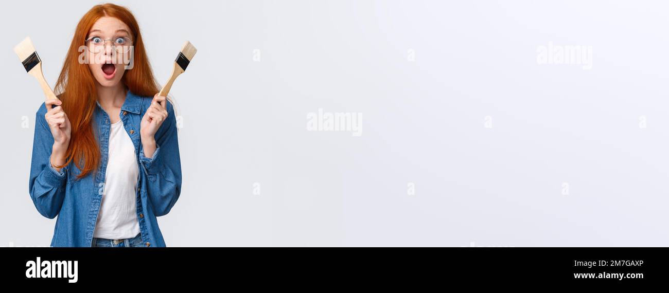 Amused and excited, wondered redhead woman creating new art, painting ...