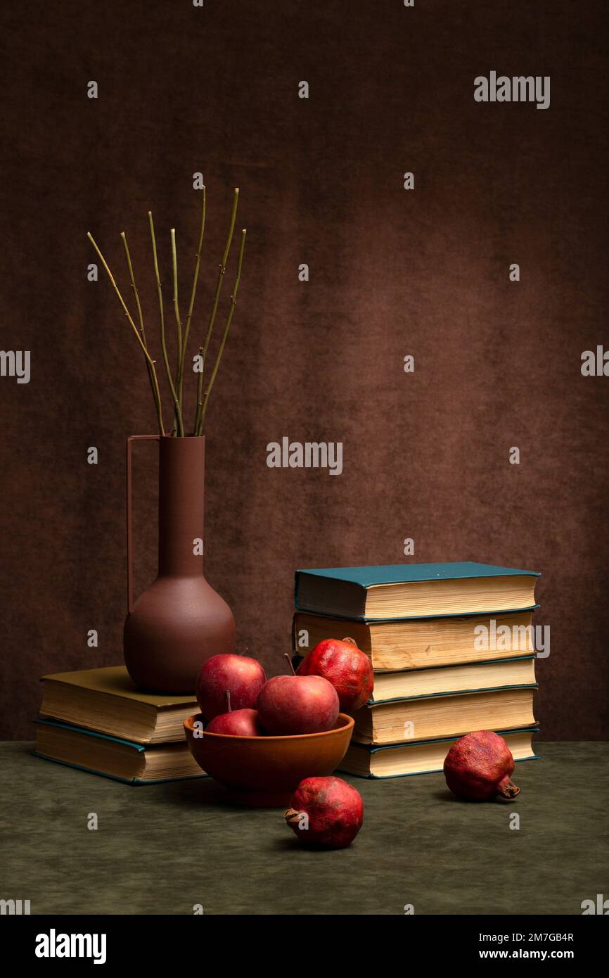 Still life with apples and pomegranates, a vase, a stack of books Stock ...