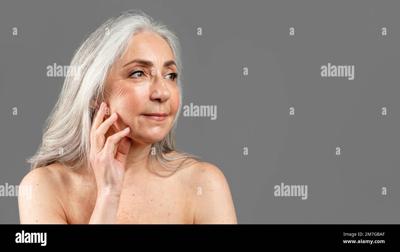Happy old caucasian lady touching her face with hands, enjoy result of ...
