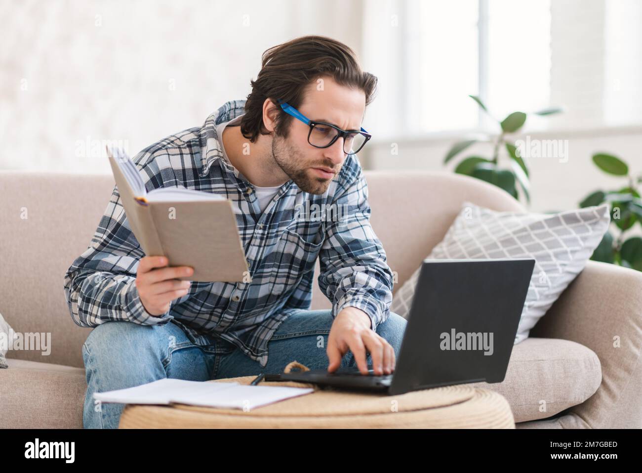 Concentrated serious smart young caucasian man student in glasses looks ...