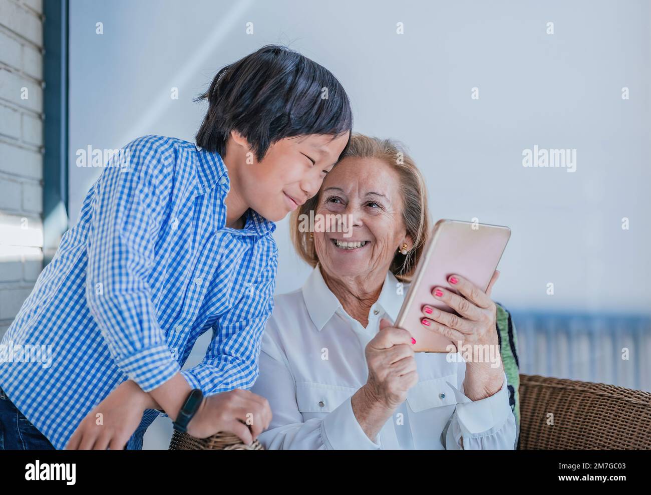 a light-haired caucasian grandmother and her dark-haired asian grandson ...