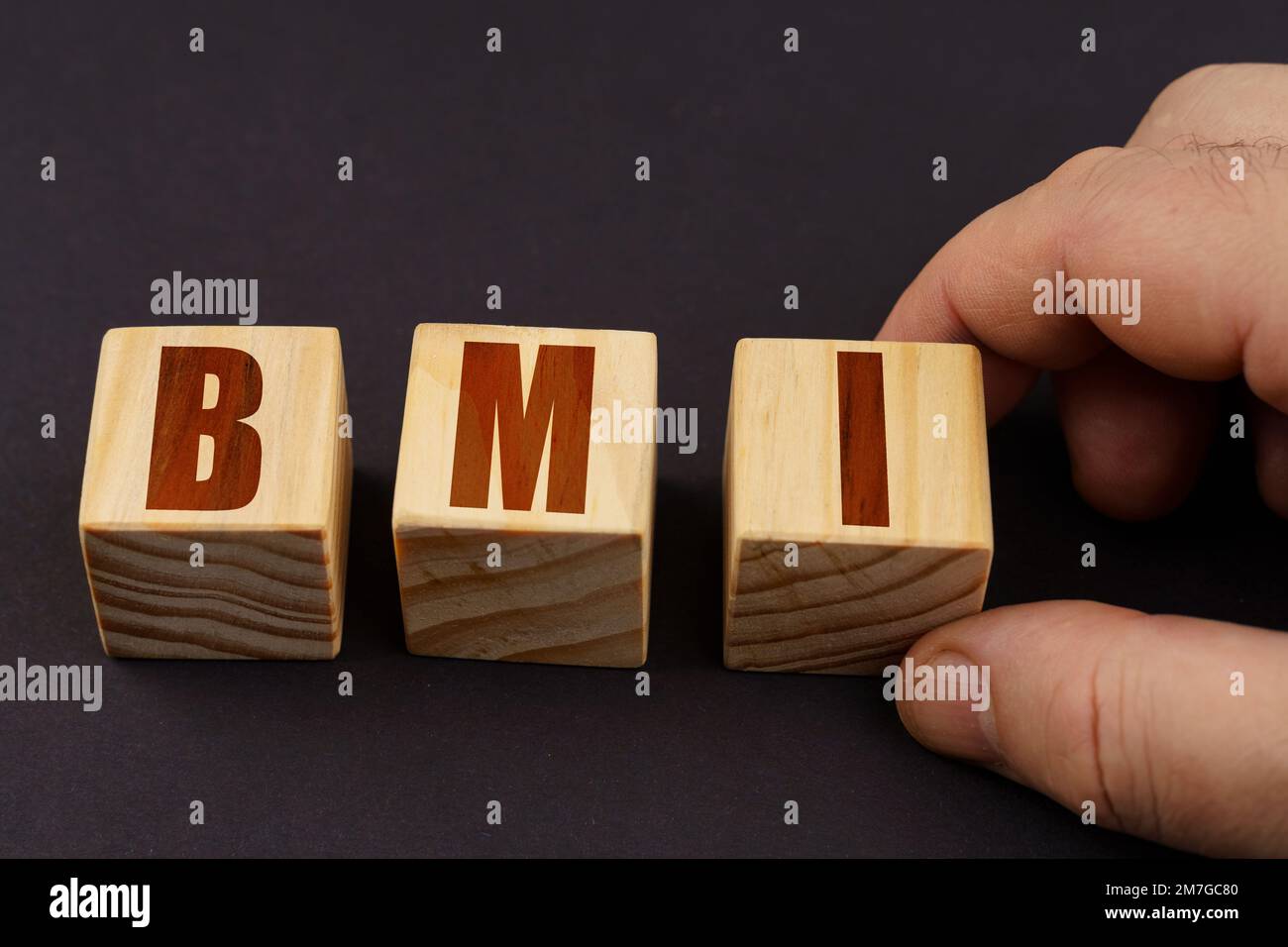 Business concept. On a black surface, a man puts cubes with the ...