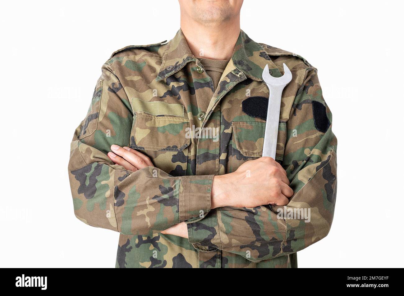 Hand of a military car mechanic with wrench against a white background ...