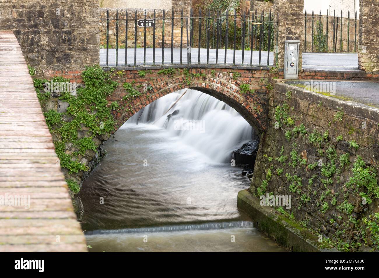 Long exposure of a watefall flowing under a bridge on the River Lim ...