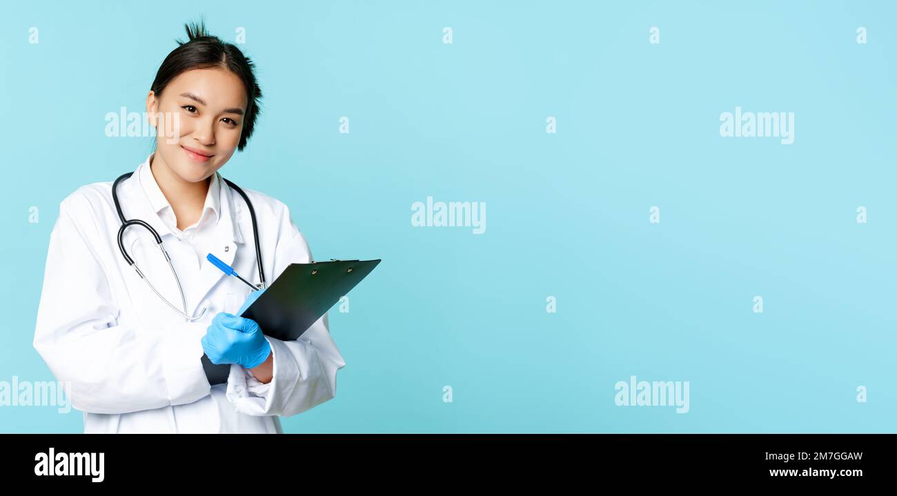 Portrait of female doctor, asian physician in medical uniform, writing ...