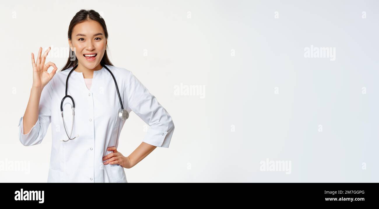 Confident female doctor, asian physician in medical uniform and ...