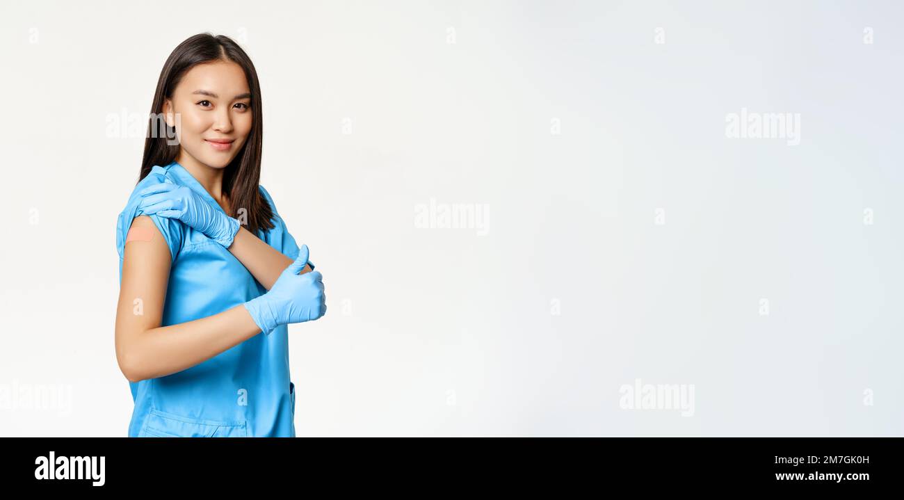 Healthcare workers and vaccination. Young asian nurse in uniform ...