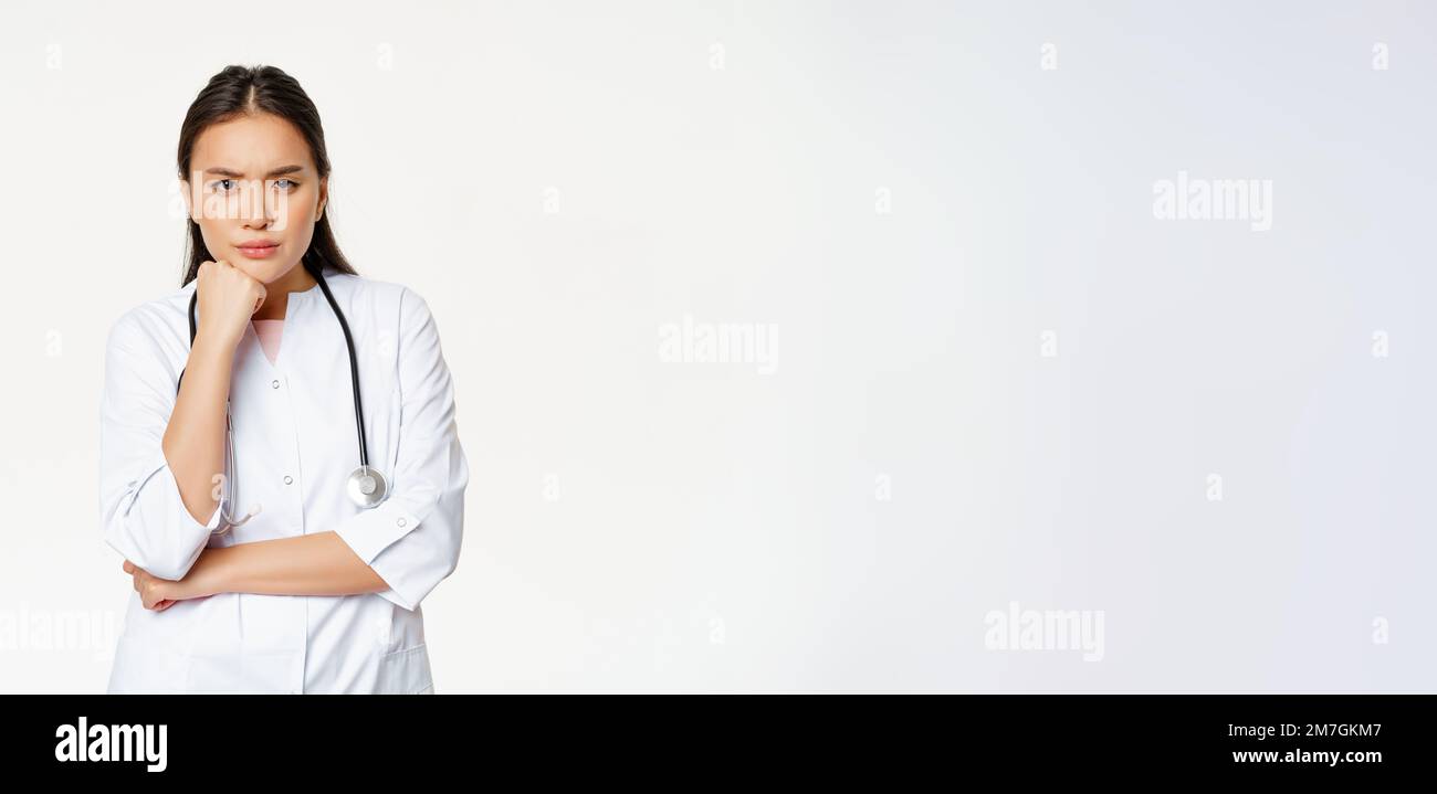 Image of angry nurse, asian female doctor looking annoyed and bothered ...