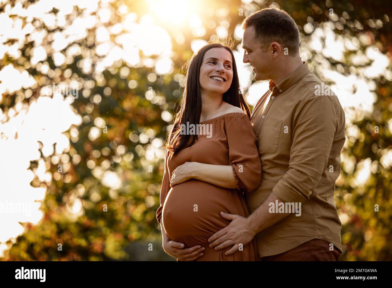 Happy pregnant couple hugging in nature.Husband with his pregnant wife ...