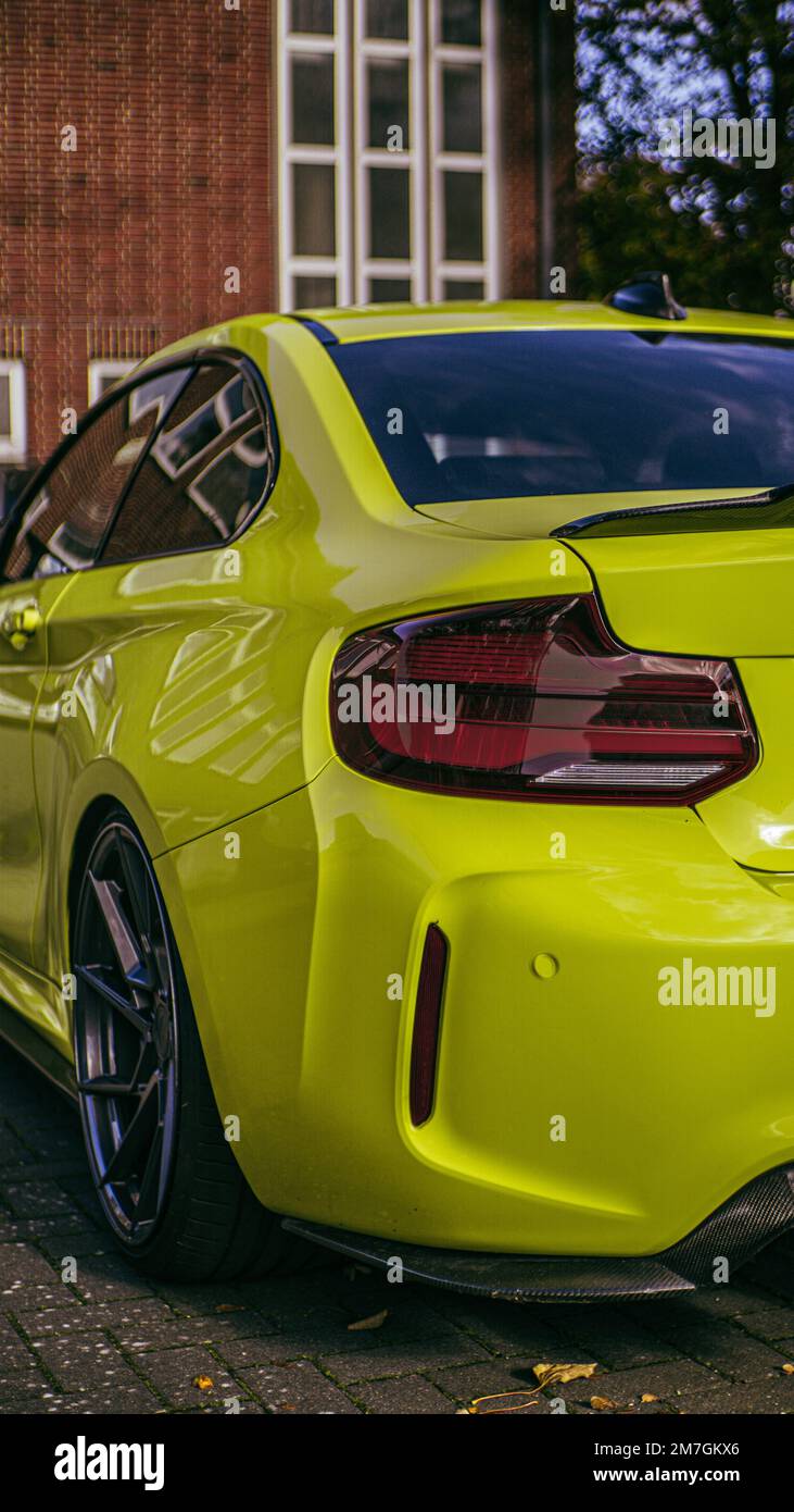 A vertical shot of the rear light of a yellow car parked on the ...