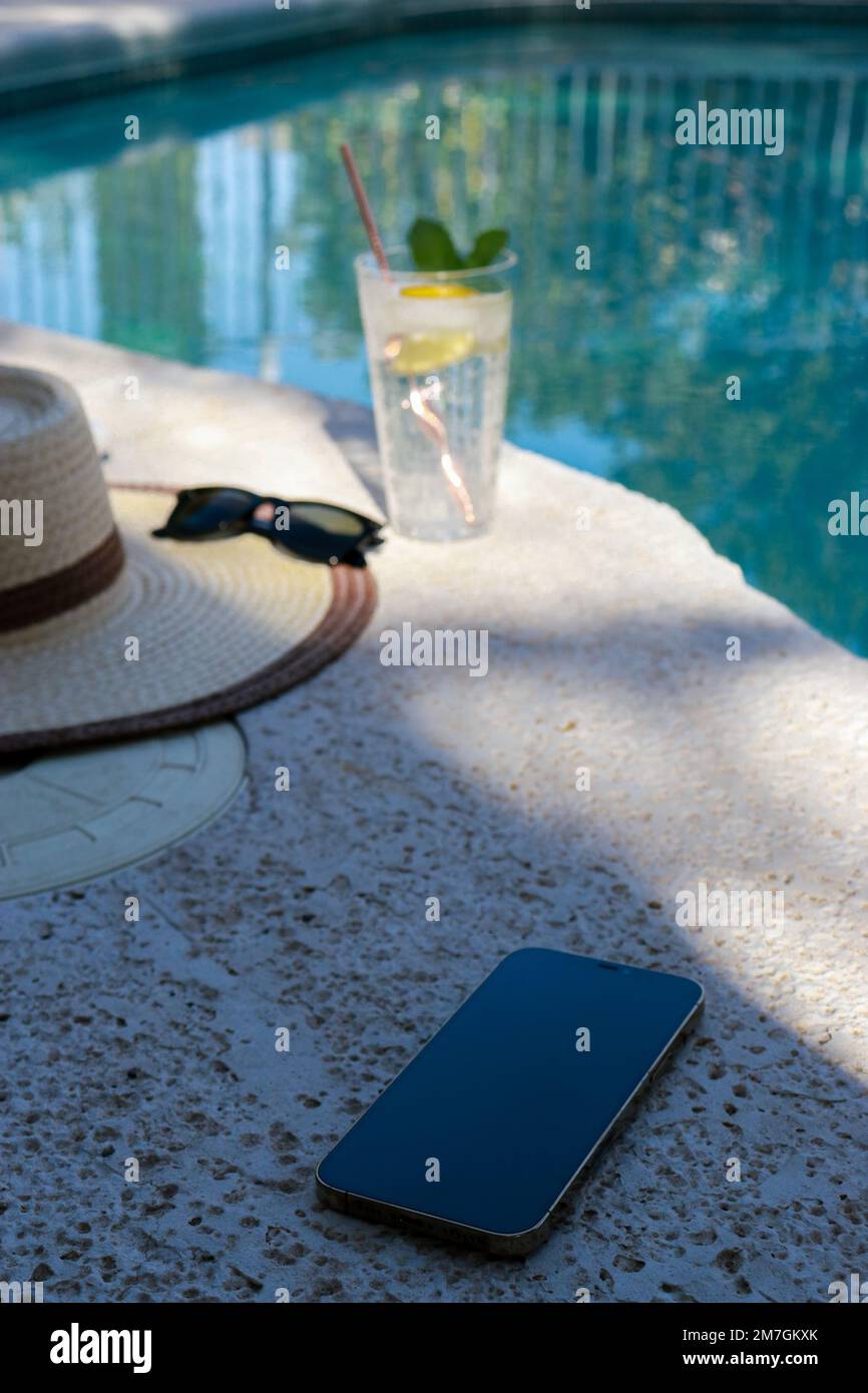 Refreshing glass of water, straw hat, sunglasses and phone off at the ...