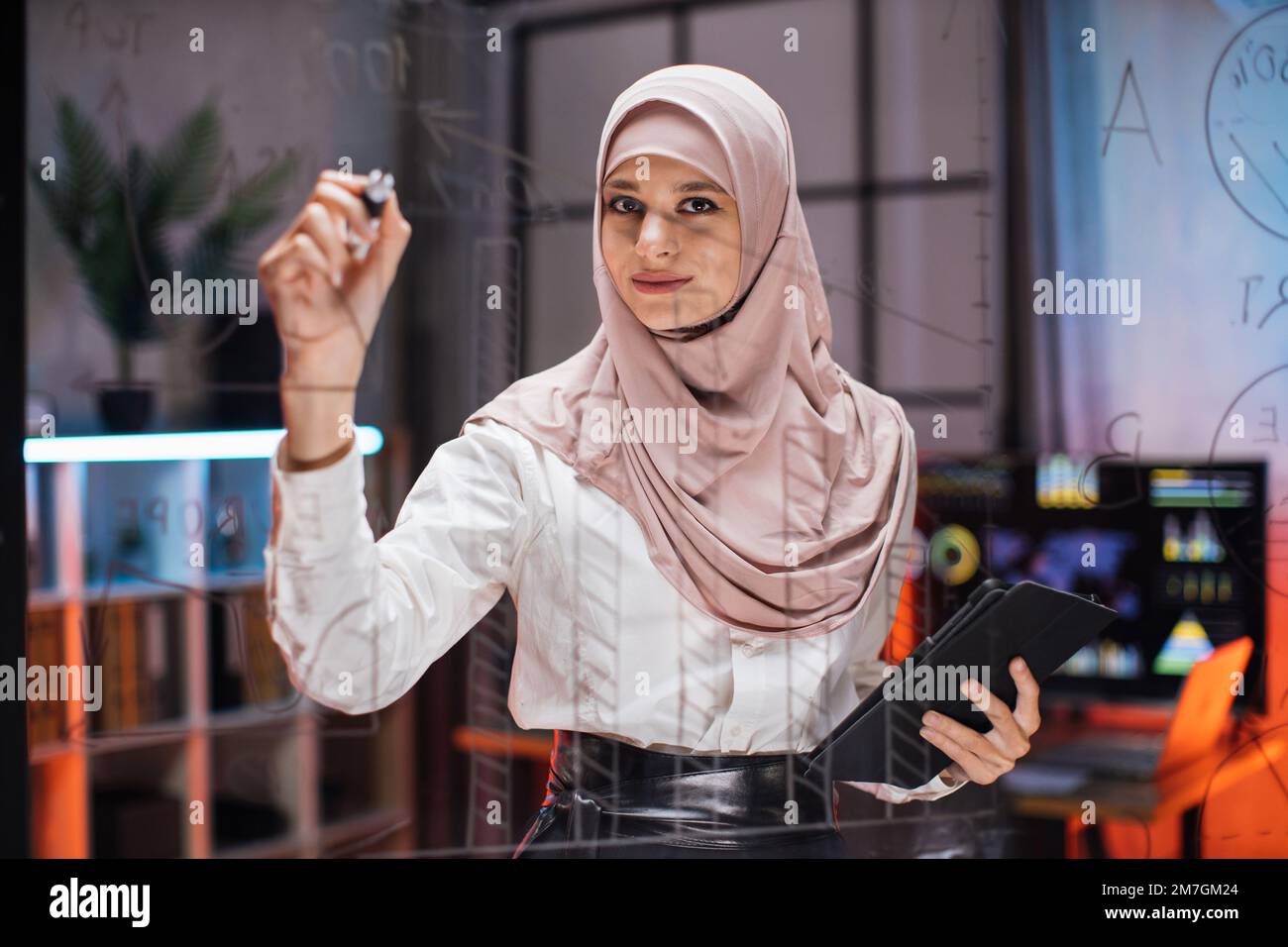 Close up through the glass view of focused young muslim businesswoman ...