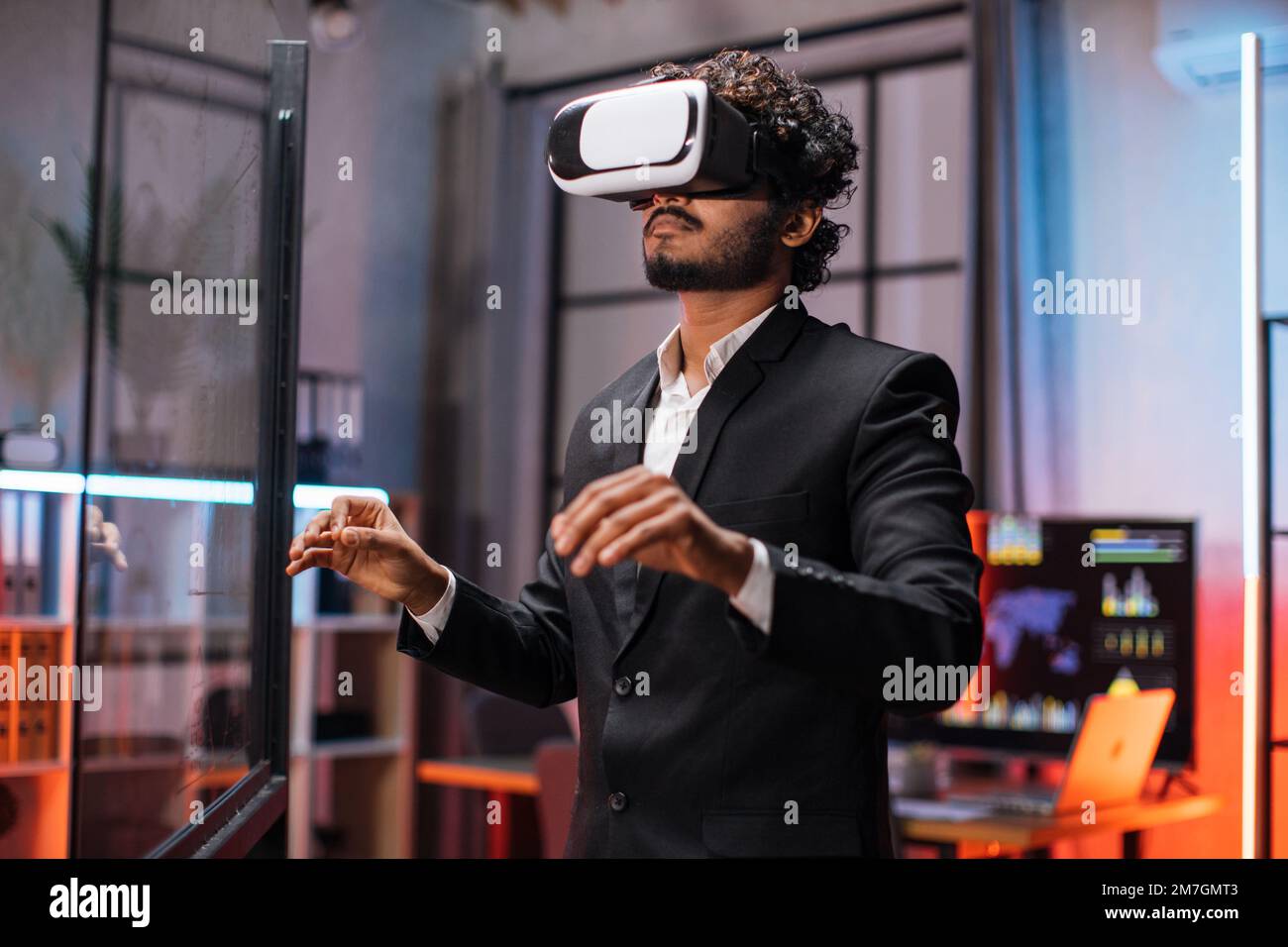 Business man in VR glasses standing at office room and gesturing with ...