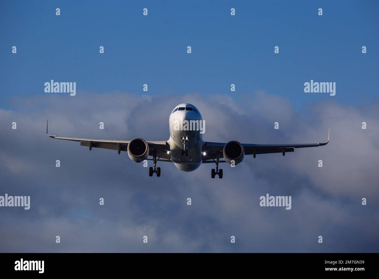 Landing plane on cloudy sky background, front view Stock Photo - Alamy