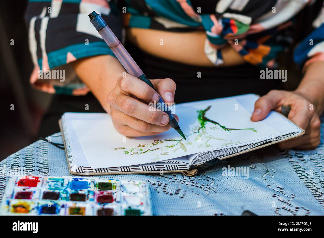 closeup of unrecognizable caucasian woman drawing with green colored ...