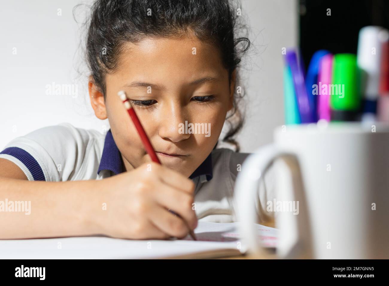 close-up of the face of a little brunette girl, very concentrated doing ...