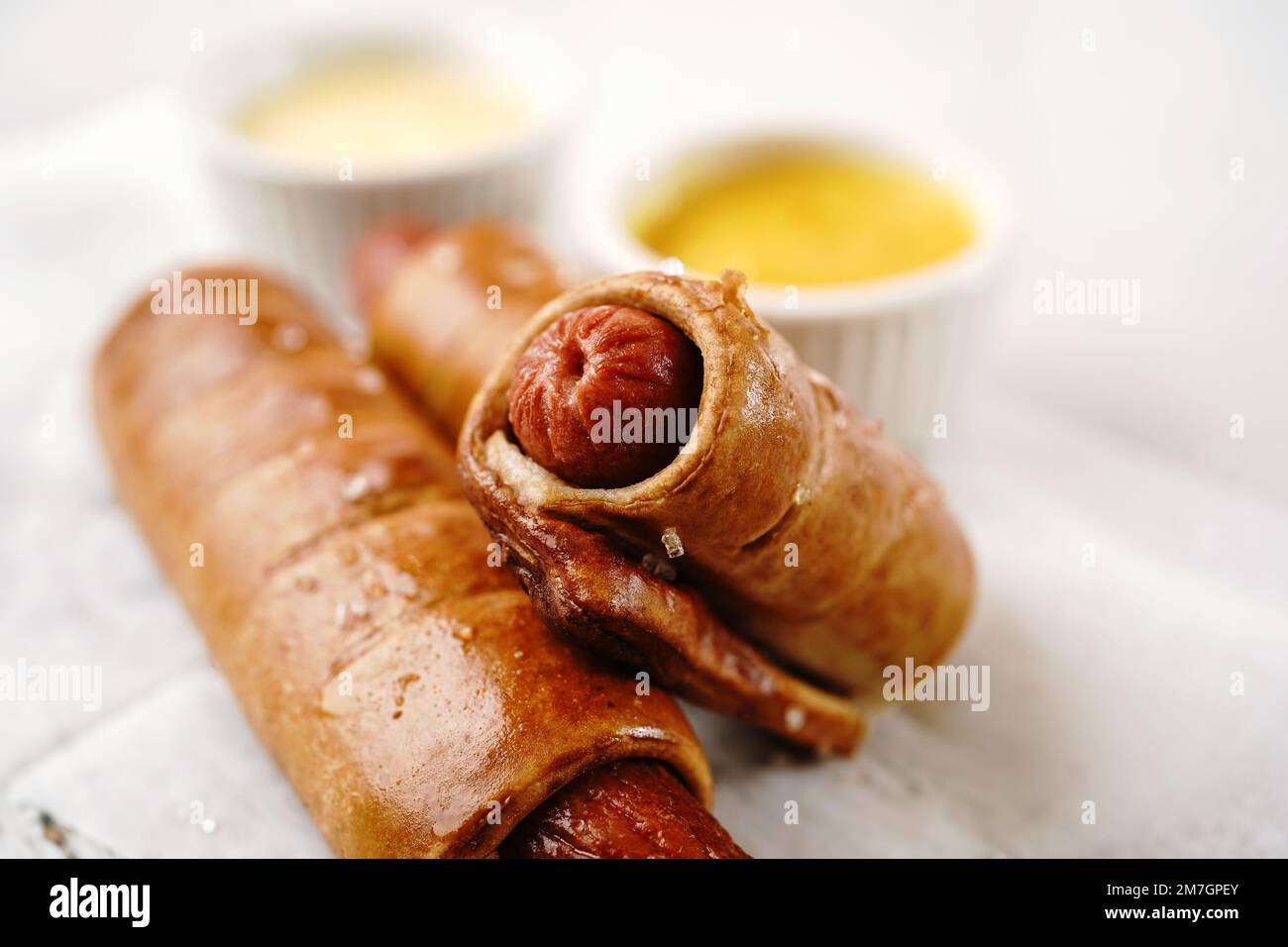 Pretzel hot dogs served with sauce, selective focus - Game day snacks ...