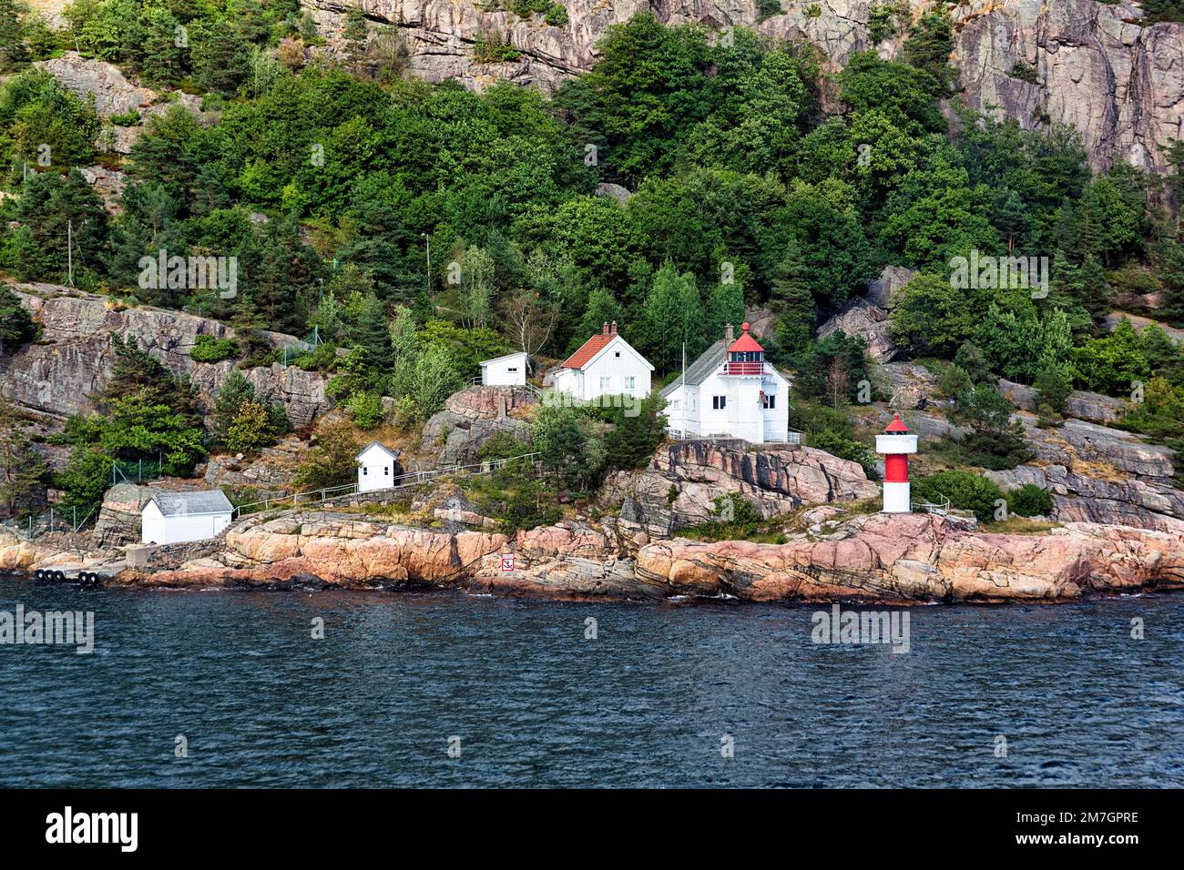 Listed red and white lighthouse on the cliffs of the Odderoya peninsula ...