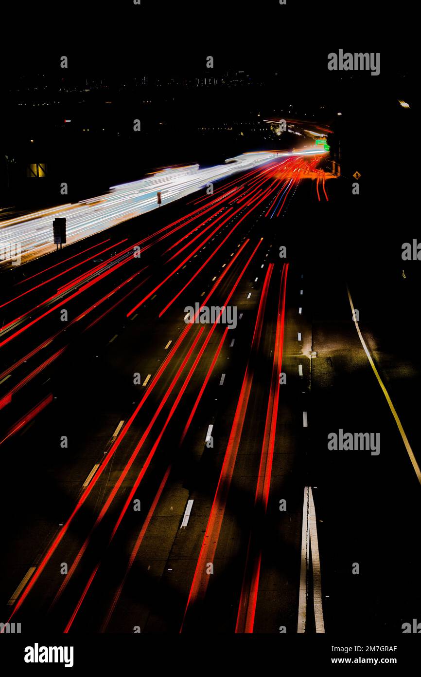 A vertical long exposure shot of car's lights on the road at night ...