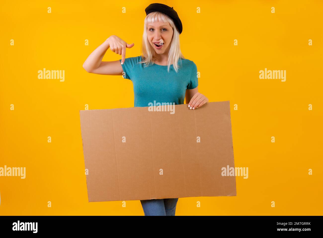Pointing smiling cardboard advertisement poster, blonde caucasian girl ...