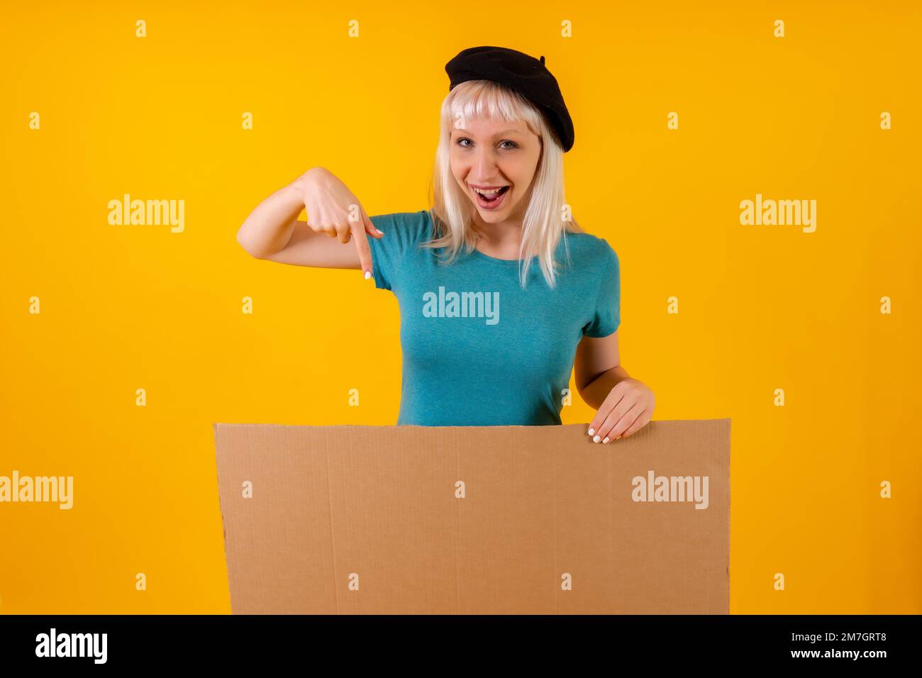 Pointing smiling cardboard advertisement poster, blonde caucasian girl ...