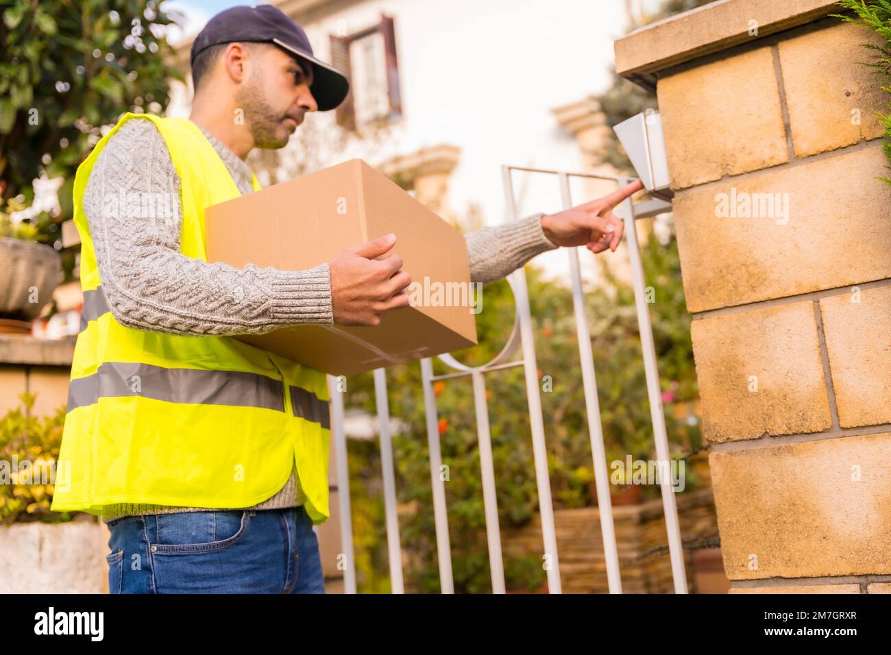 Package delivery carrier with a box from an online store, ringing the ...