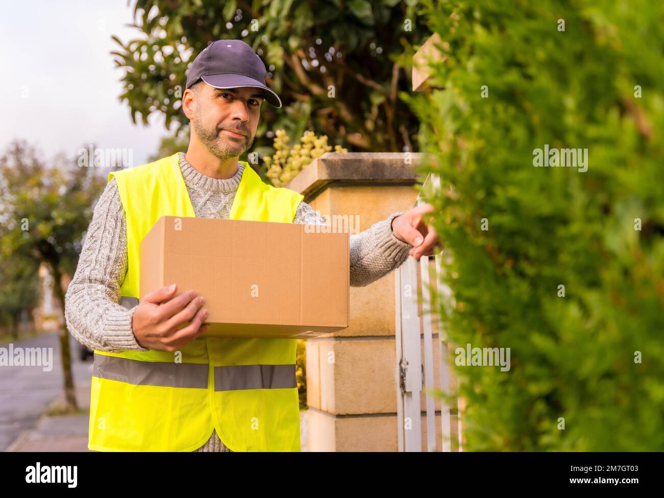Package delivery carrier with a box from an online store, ringing the ...