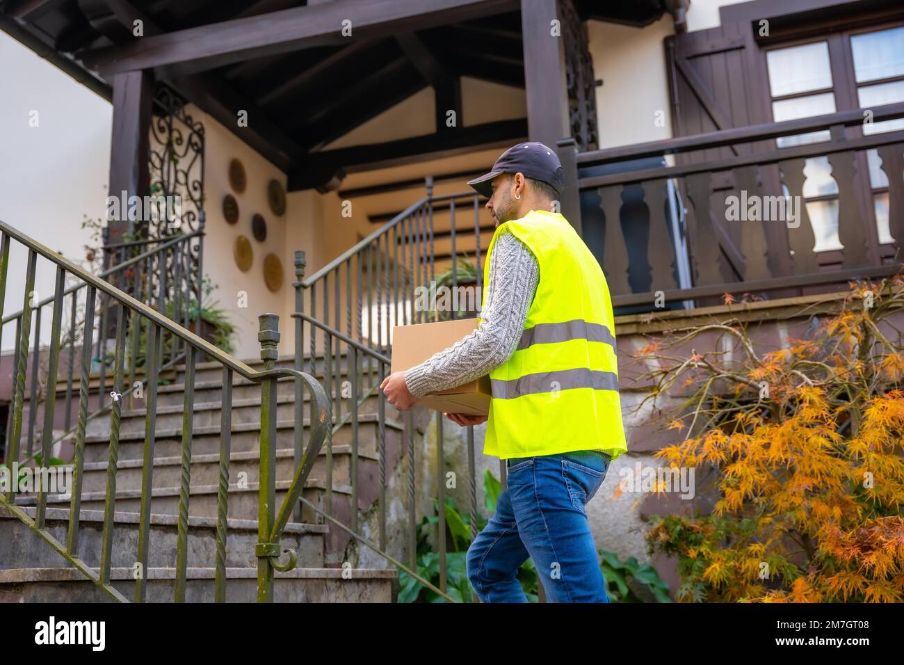 A young delivery man in a protective uniform at the delivery of the ...