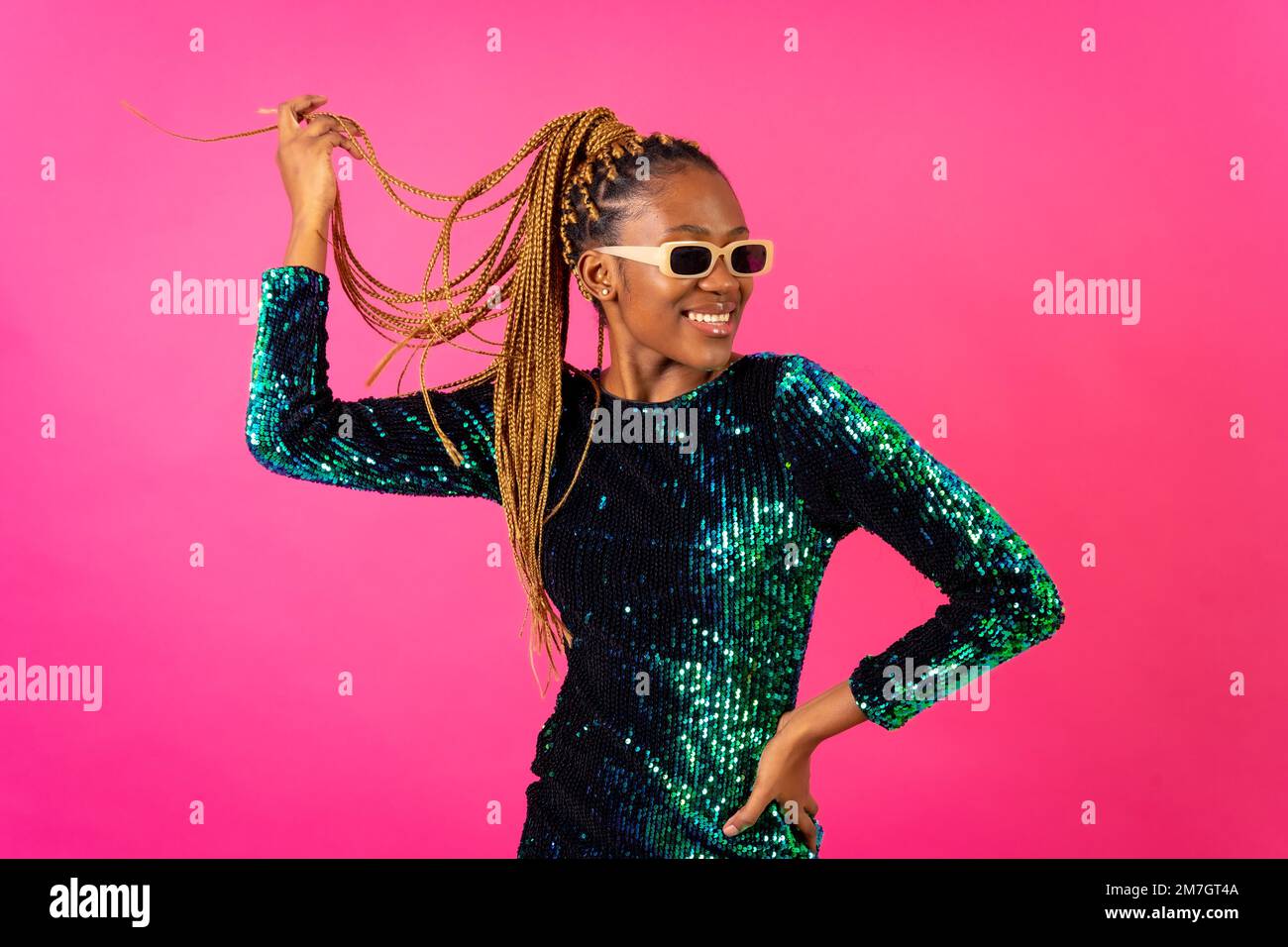 A black ethnic woman with party braids on a pink background, smiling ...