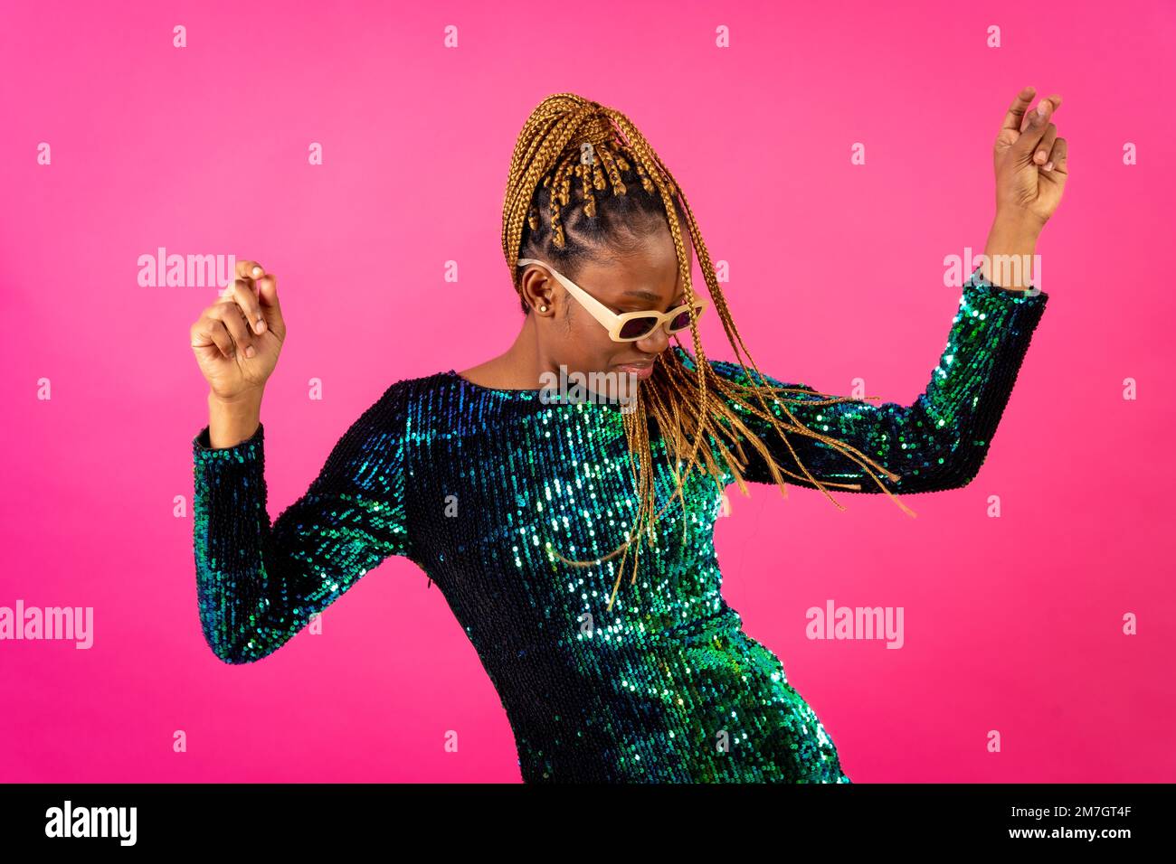 A black ethnic woman with party braids on a pink background, smiling ...