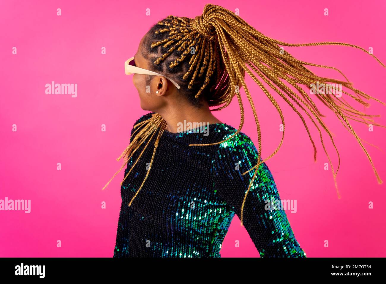 A black ethnic woman with party braids on a pink background, smiling ...