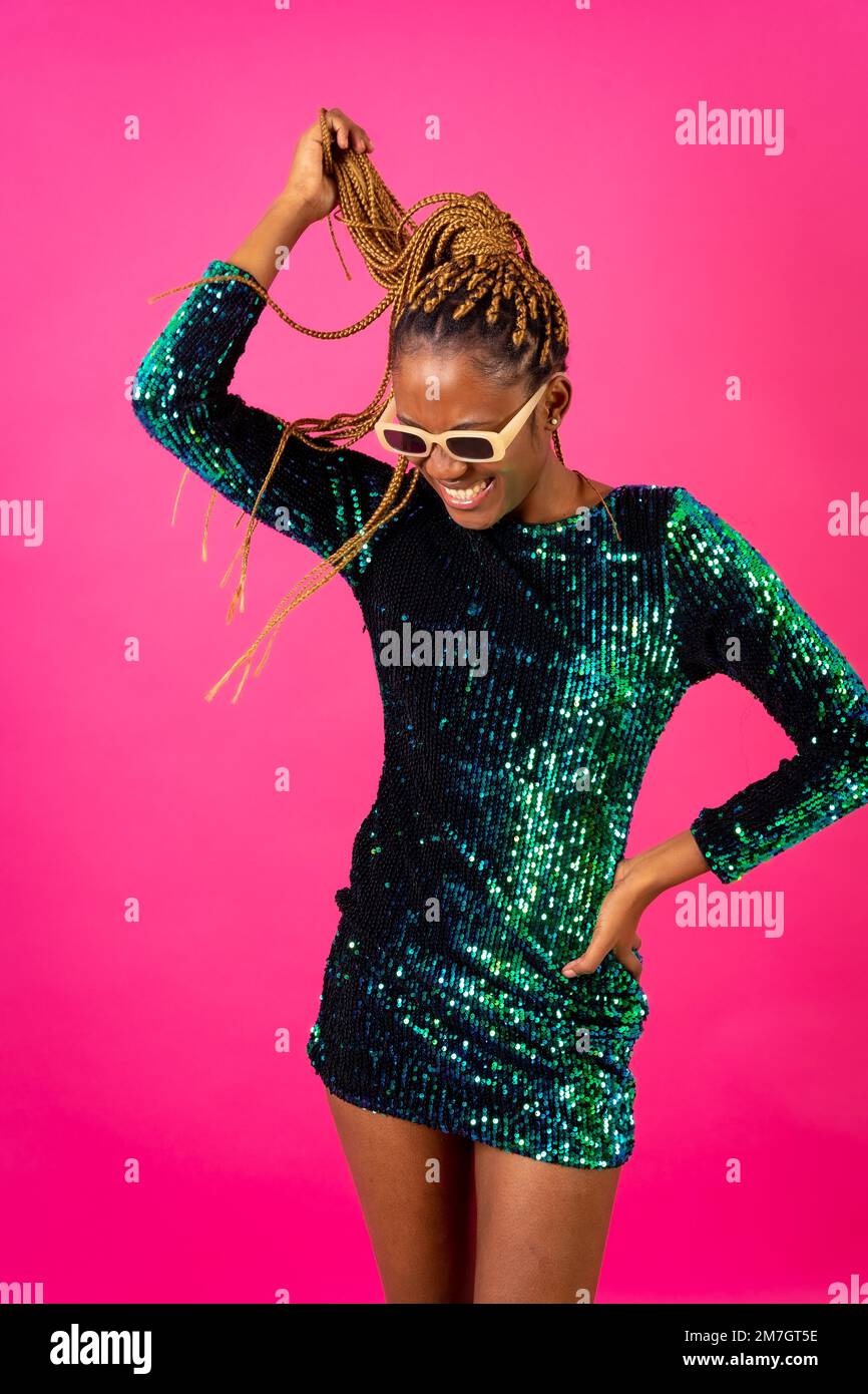 African young woman with party braids on a pink background, smiling in ...